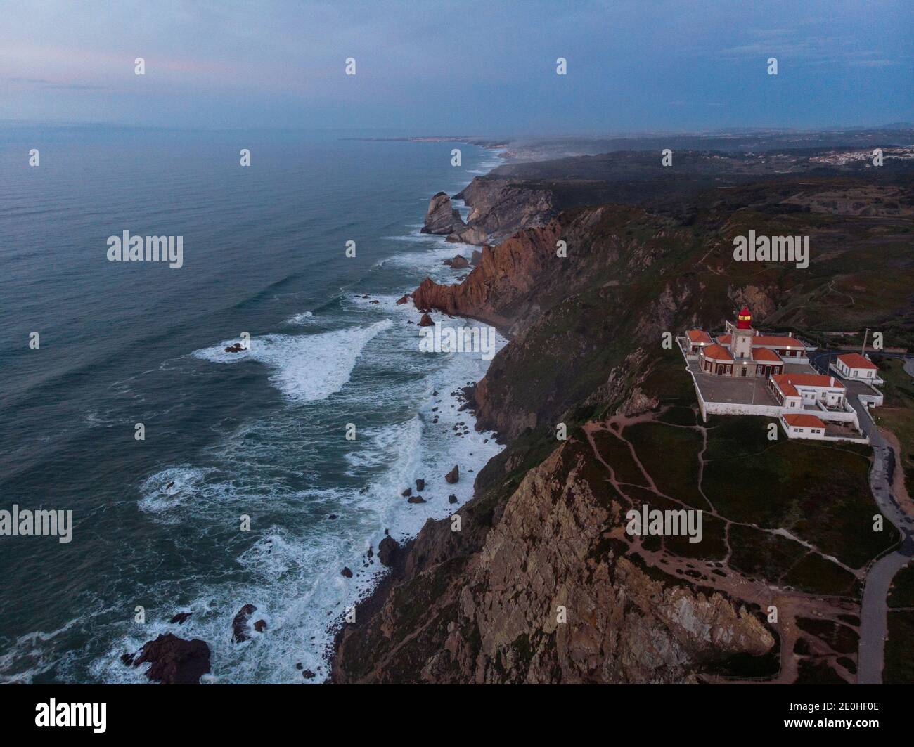 Aerial view of Cabo da Roca lighthouse steep rocky cliffs beach coast ...