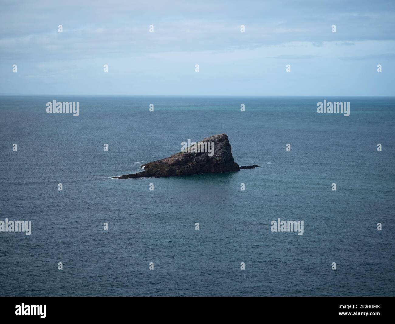 Tiny small islet rock stack sticking out of atlantic ocean at Cap ...