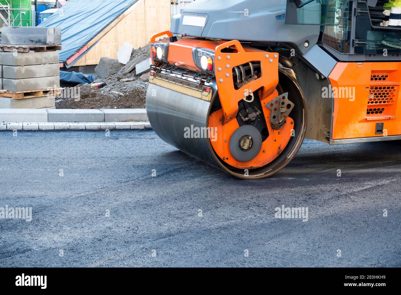 a Modern heavy asphalt roller that stack and press hot asphalt. Yellow ...