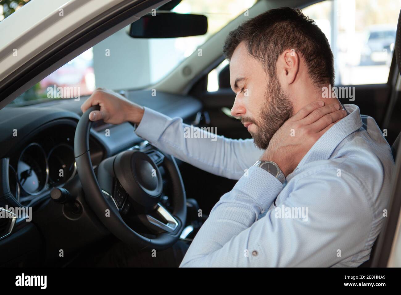 Young man rubbing his aching neck, looking tired from driving. Male ...