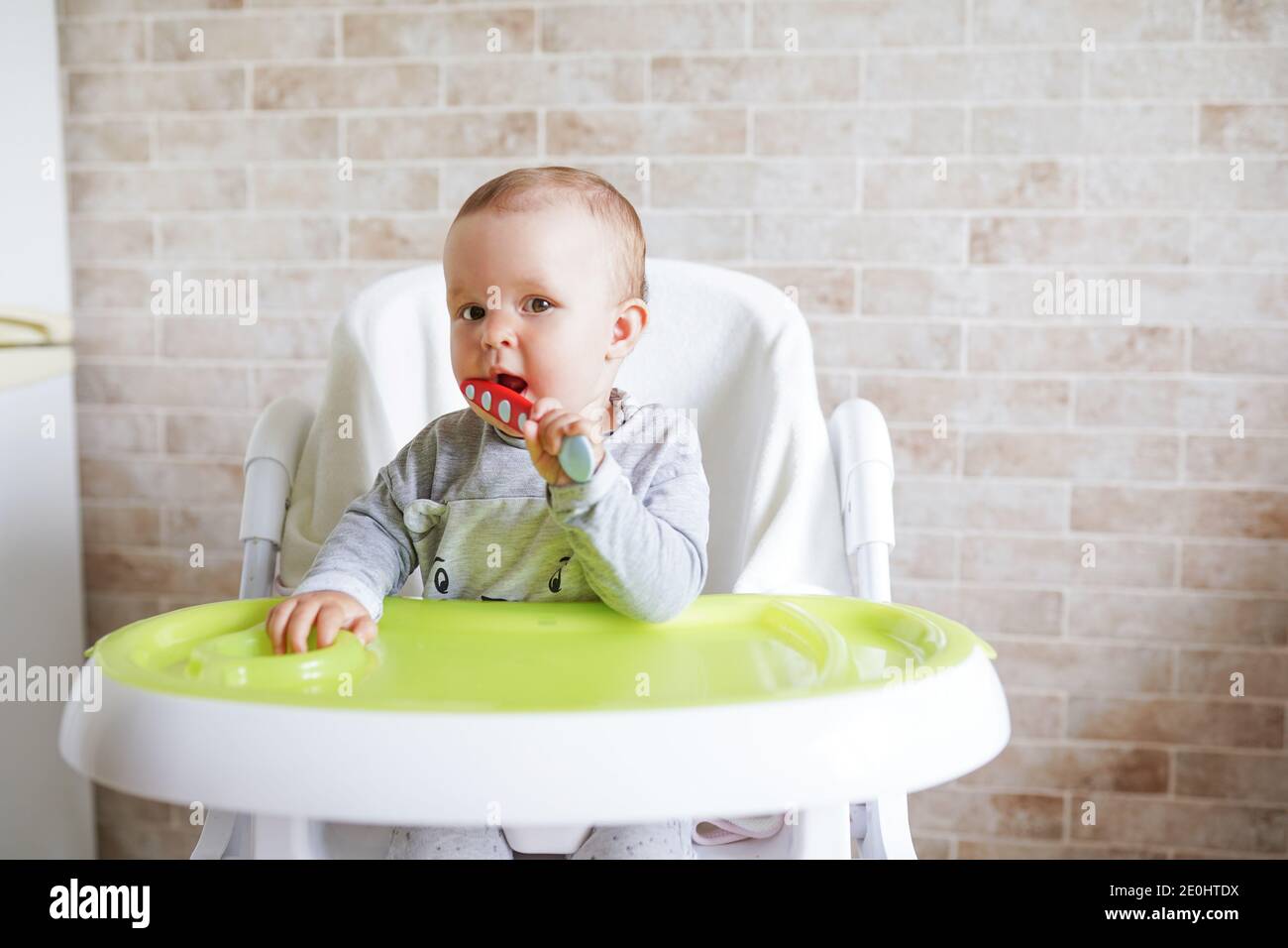 Baby with spoon on the chair In the dining room,Smiling and happy child ...