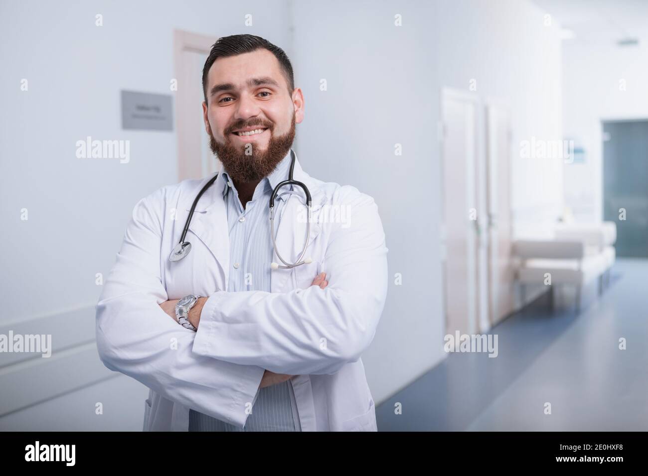 Happy bearded doctor smiling to the camera, enjying working in a modern ...