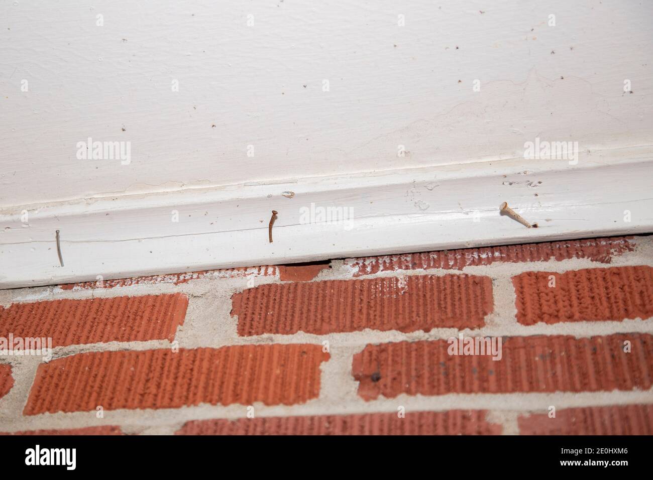 Rusty nail on molding on a brick wall Stock Photo - Alamy