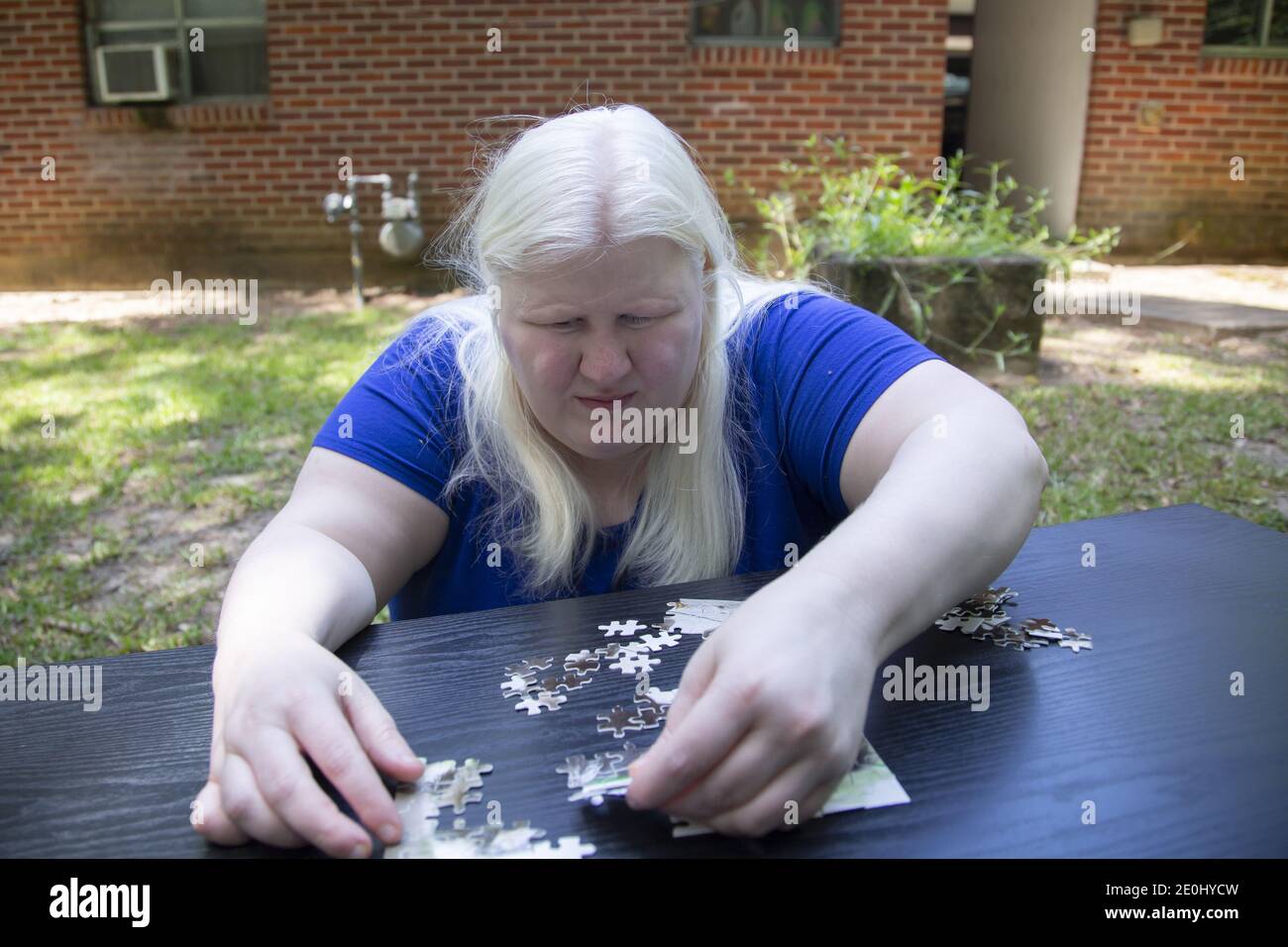 Woman placing a puzzle piece into the correct spot Stock Photo - Alamy