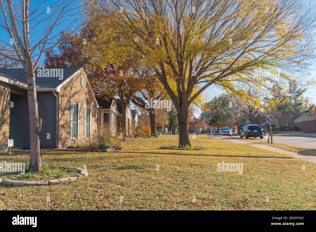 Typical suburban corner house with colorful fall foliage in suburbs ...