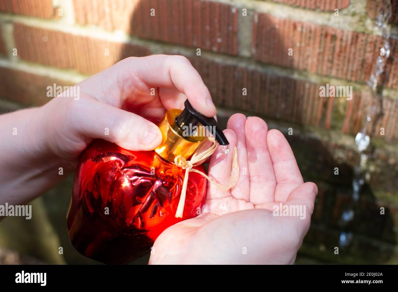 Woman washing her hands using the outdoor spigot outside Stock Photo ...