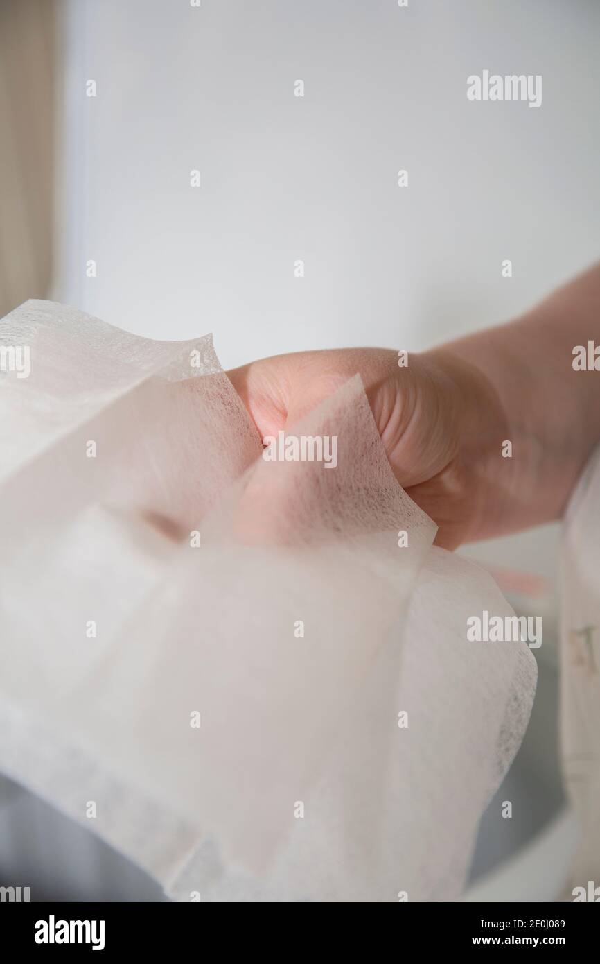A woman's hand as she holds dryer sheets for laundry Stock Photo - Alamy
