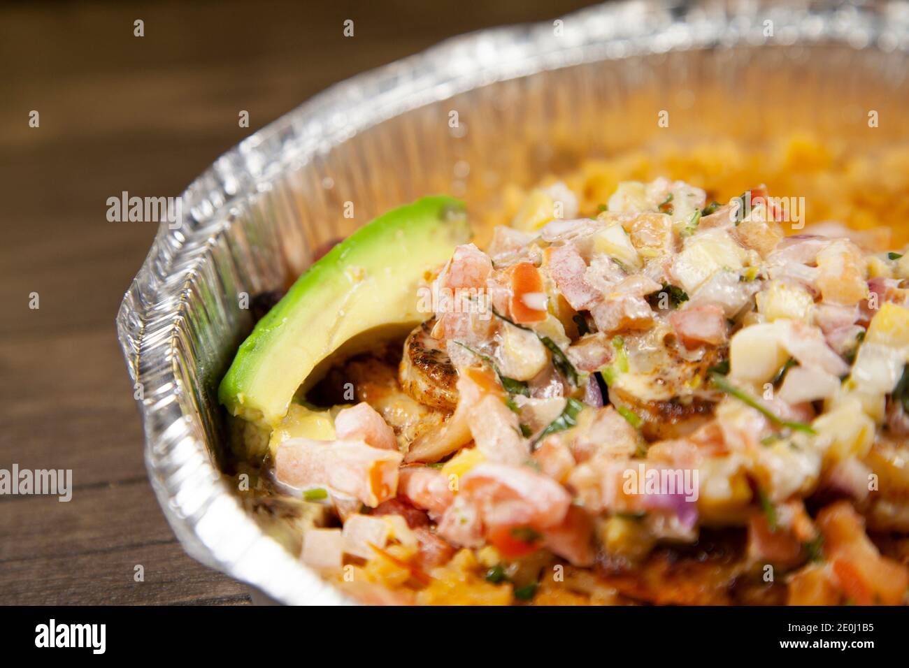 Baked chicken and shrimp over rice, smothered in a mango salsa with ...