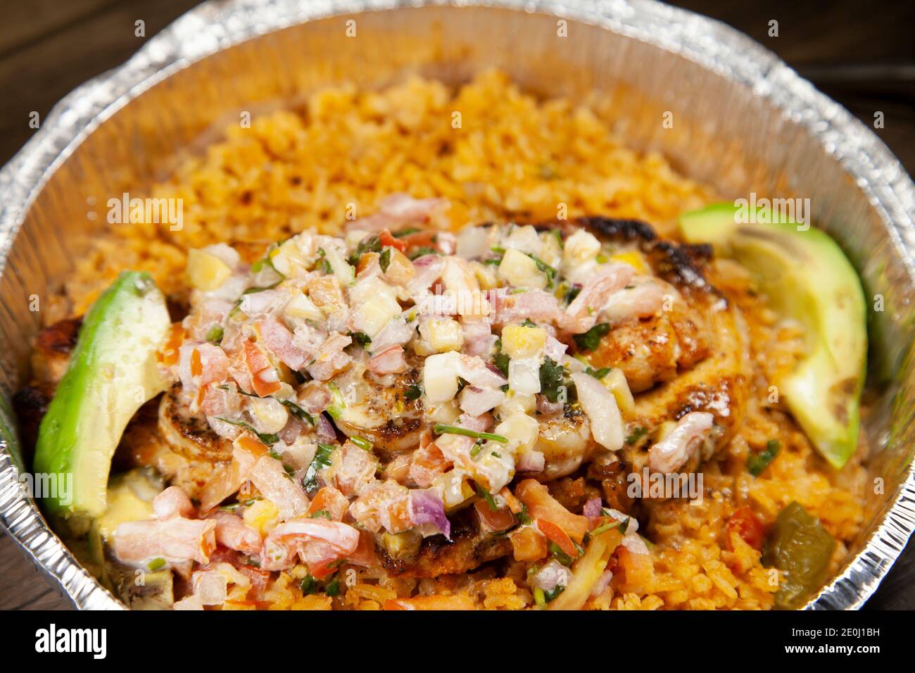 Baked chicken and shrimp over rice, smothered in a mango salsa with ...