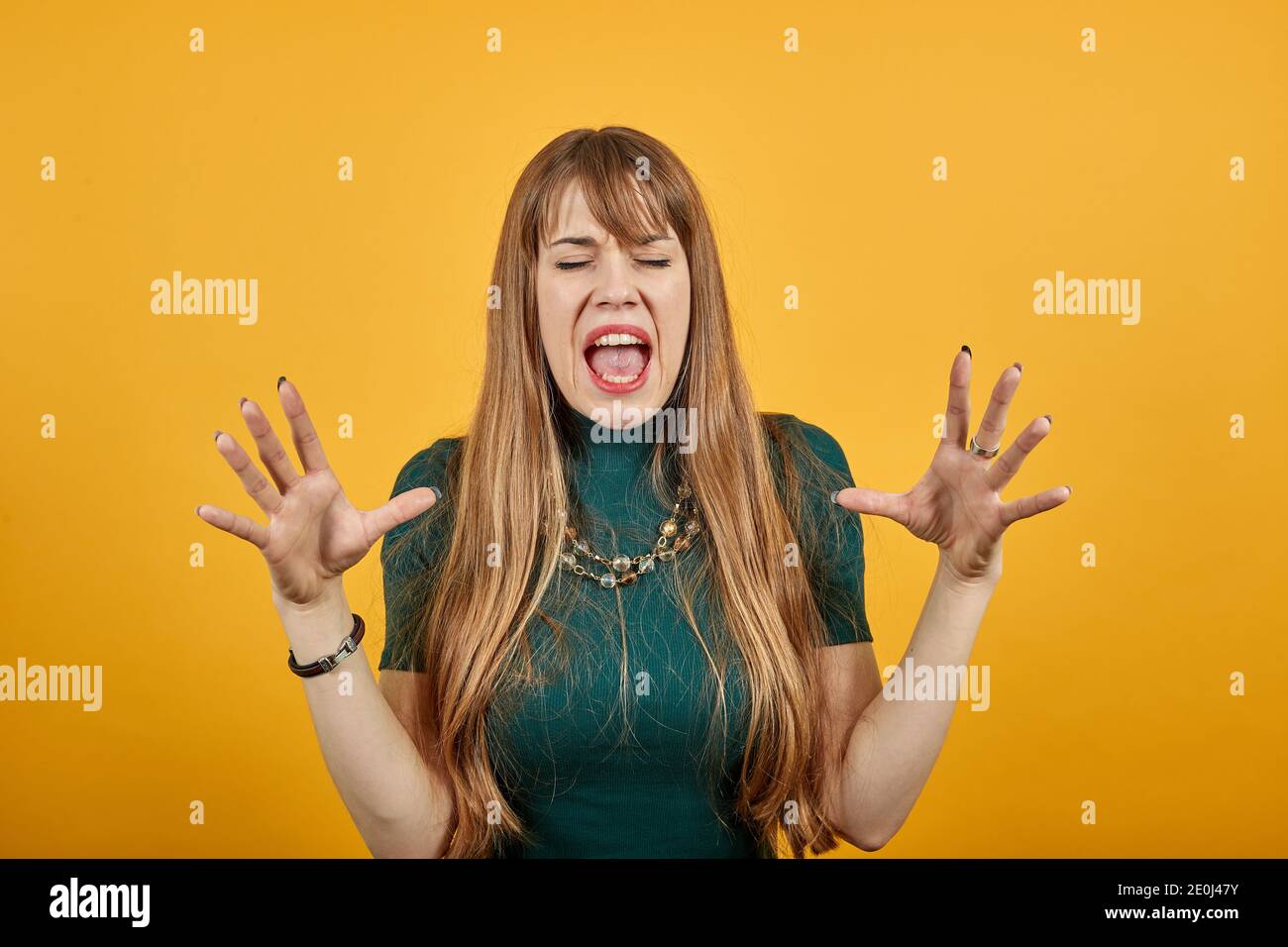 Young beautiful doing claw gesture as cat, aggressive crazy expression ...