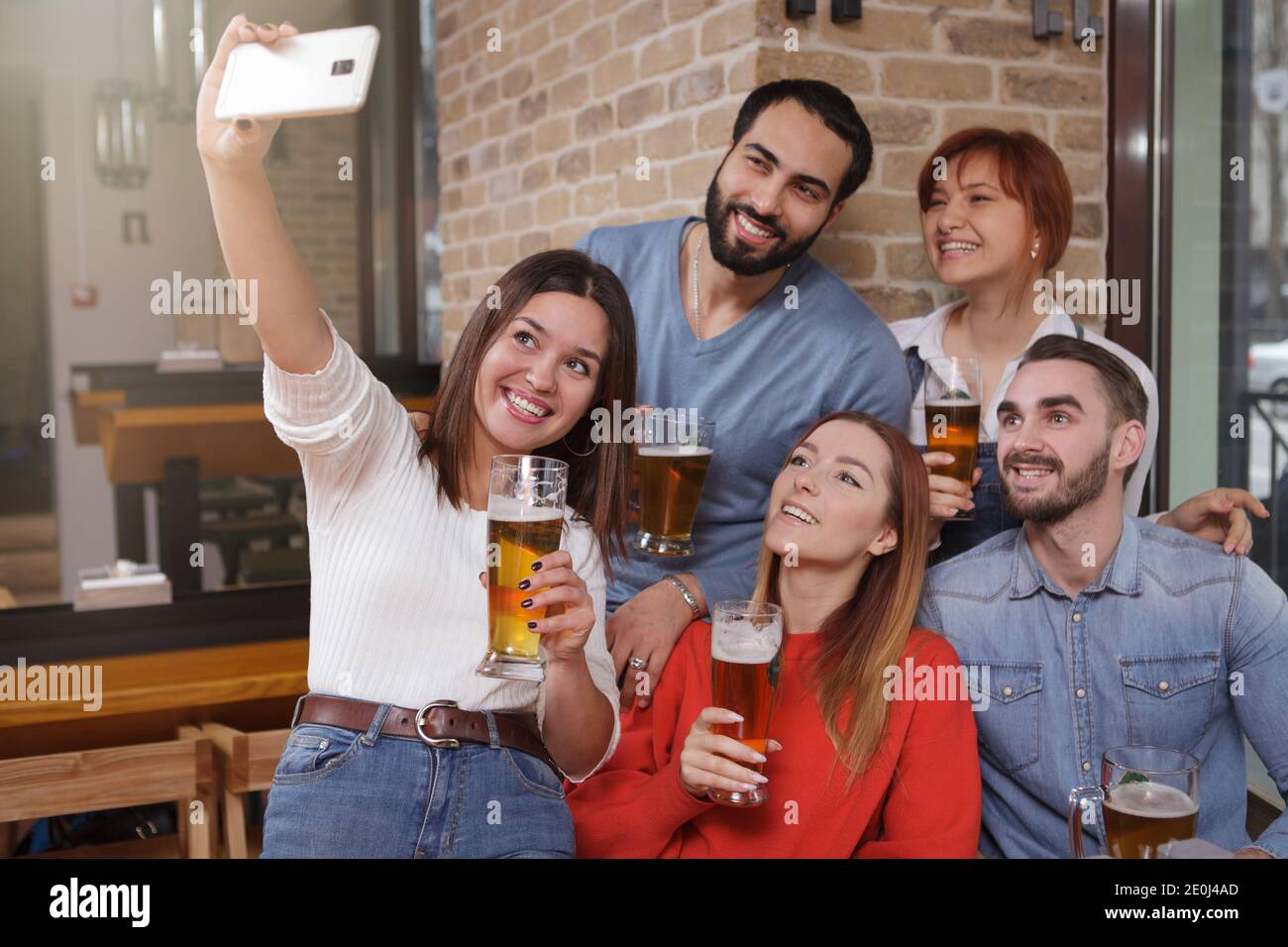 Group of friends taking selfies at beer pub. Young people enjoying ...