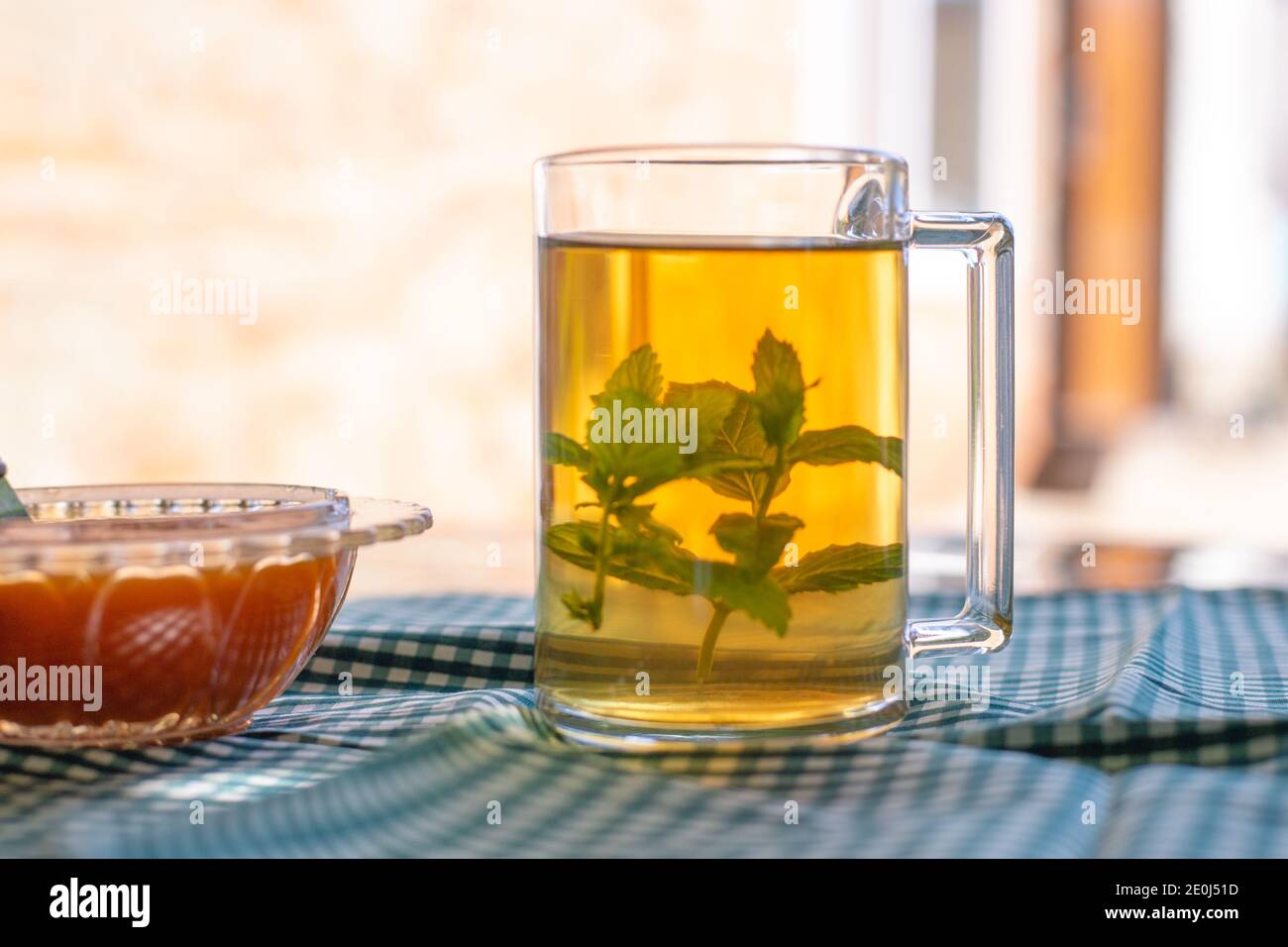 Flavored green tea with mint in a transparent mug. Open-air morning tea ...