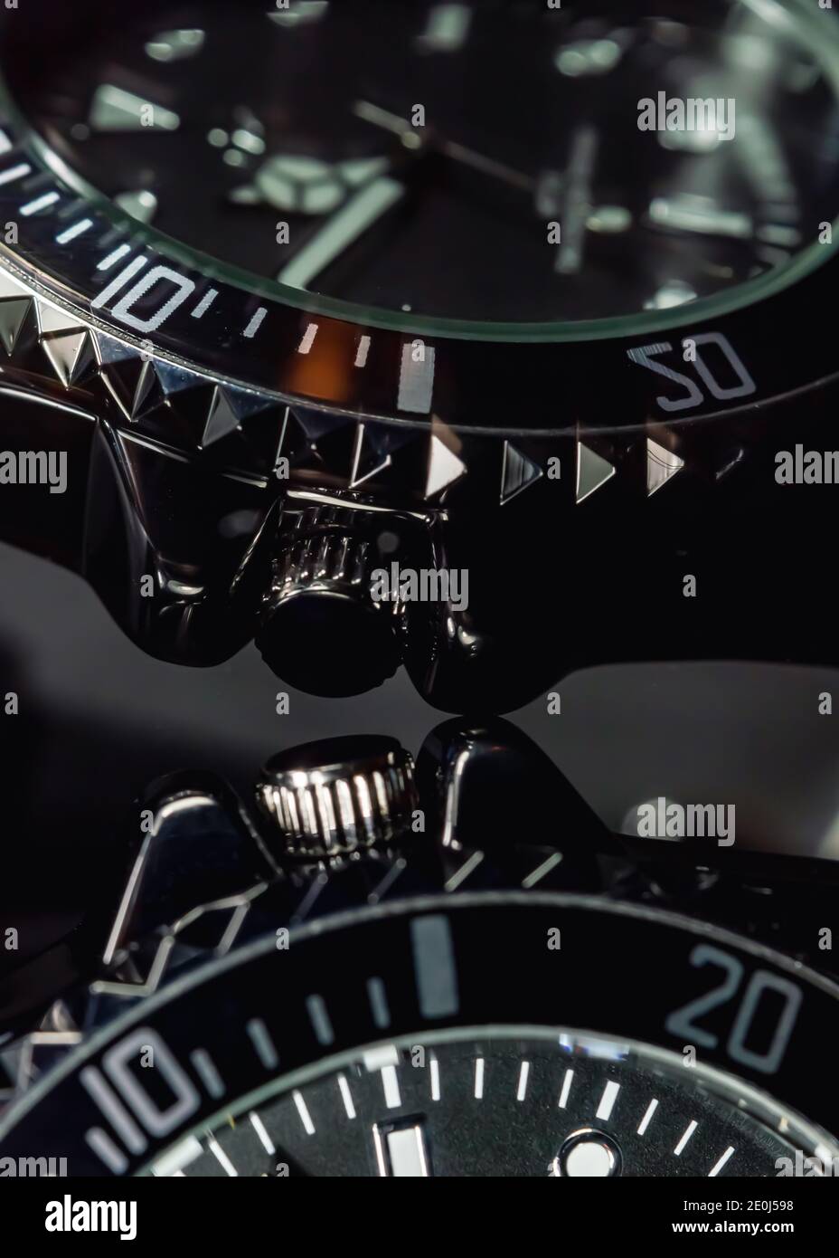 Close-up of a men's wristwatch and its mirror image on a reflective ...