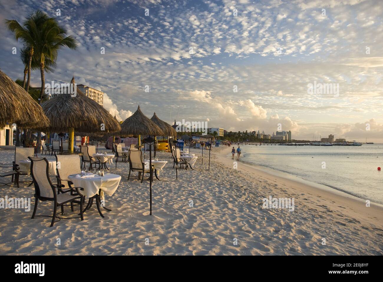 Tables are set for dinner at sunset on the High Rise Hotel area beach ...