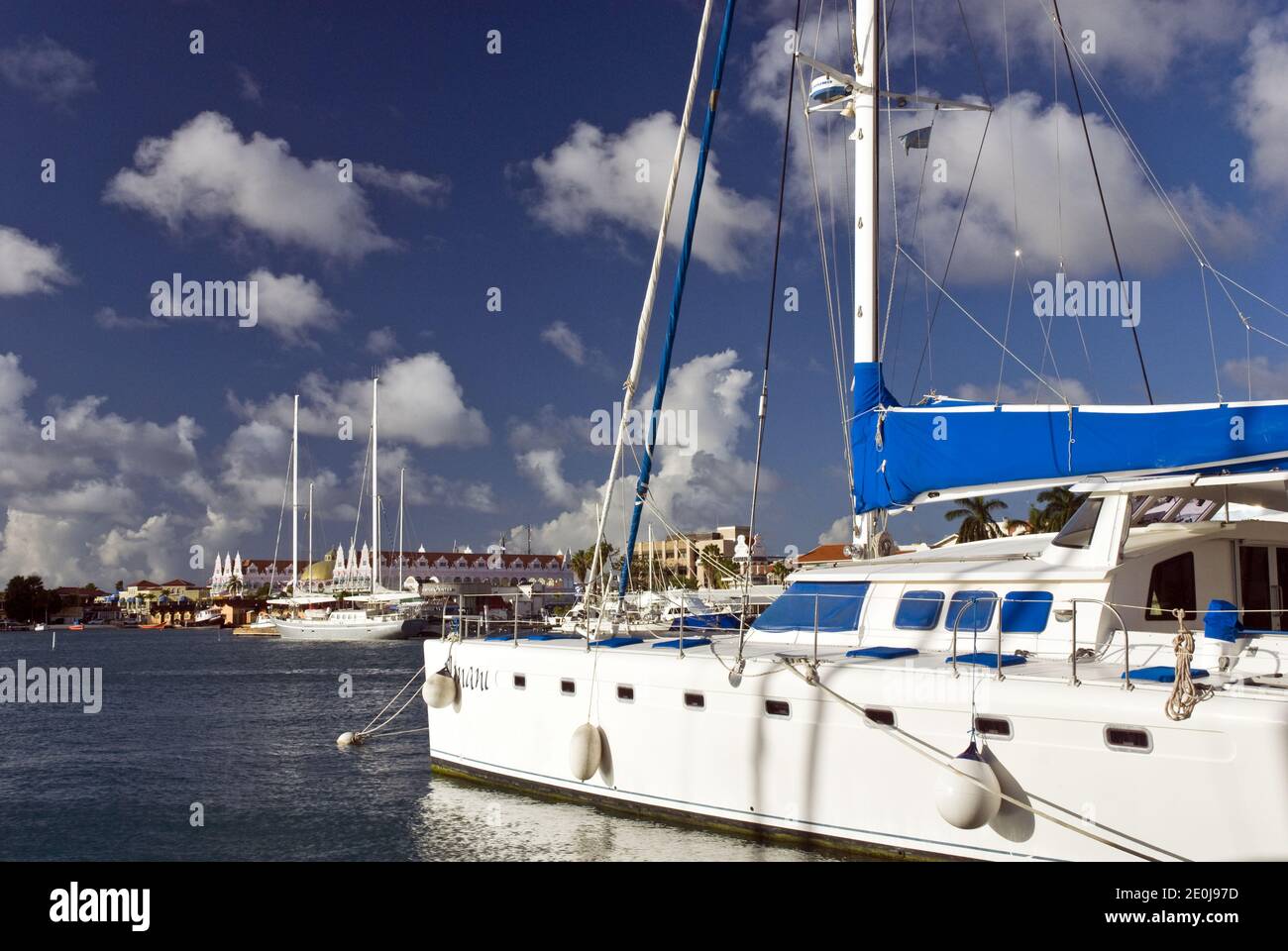 A large catamaran moored in the marina, with Dutch Colonial buildings ...
