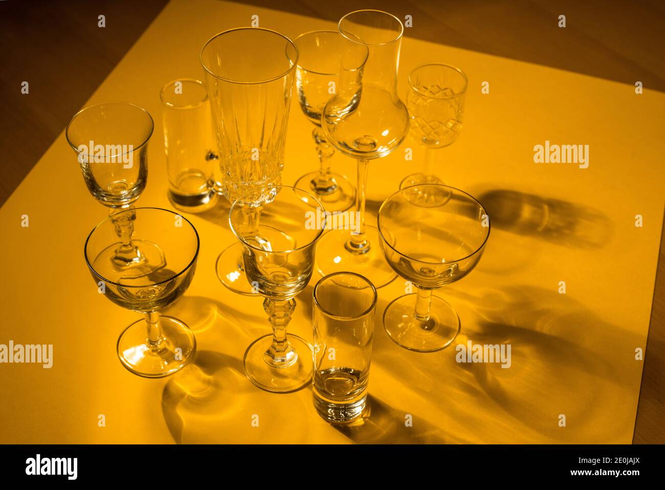 Different types of empty glasses on yellow background Stock Photo - Alamy