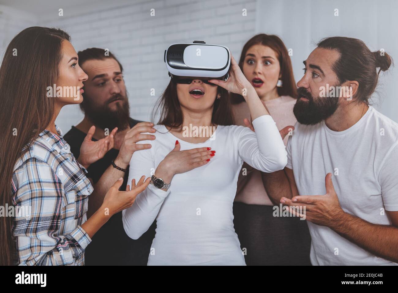 Young woman looking overwhelmed and shocked, wearing virtual reality ...