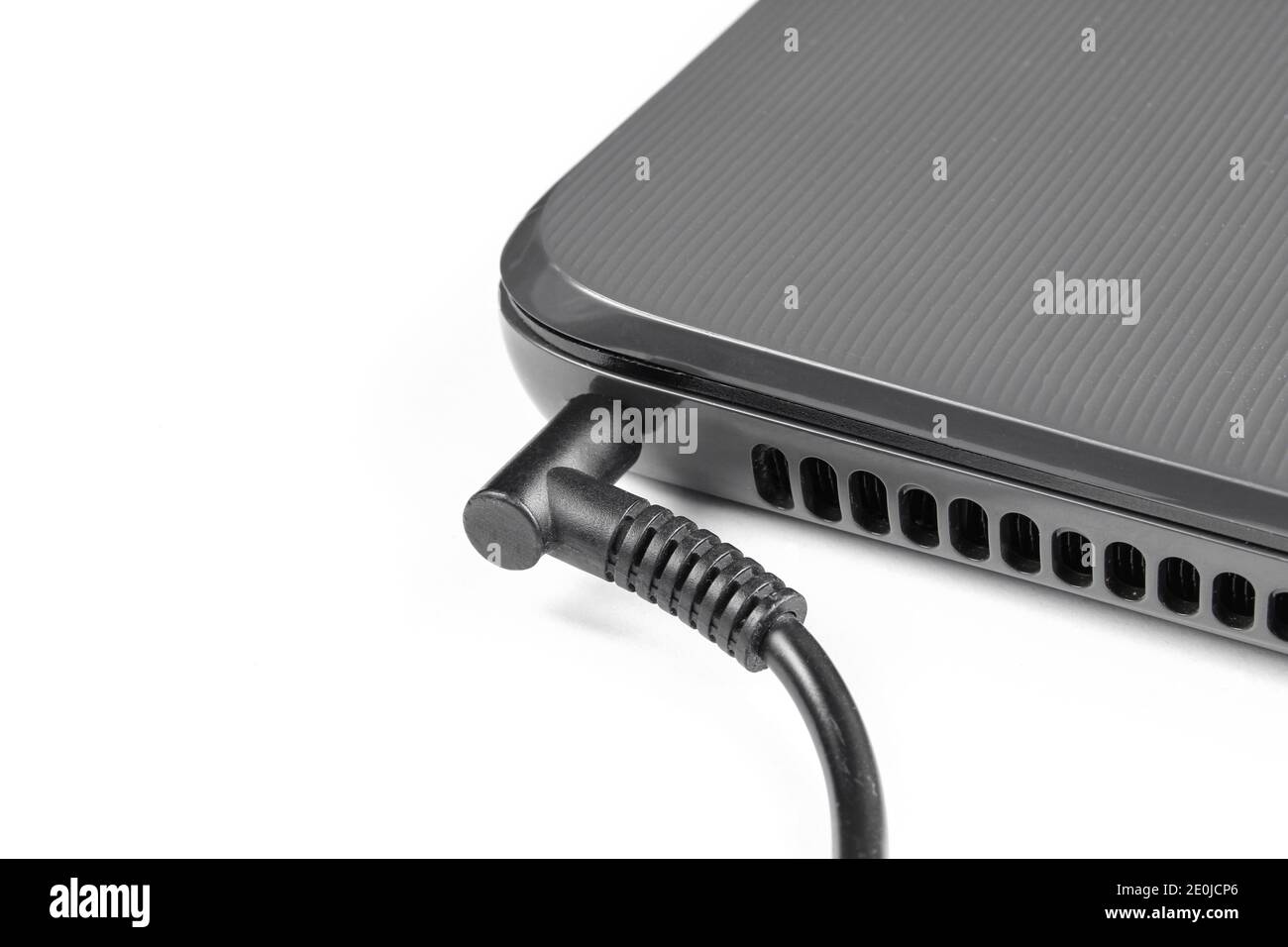 Electricity charging black laptop isolated on white background. Closeup ...