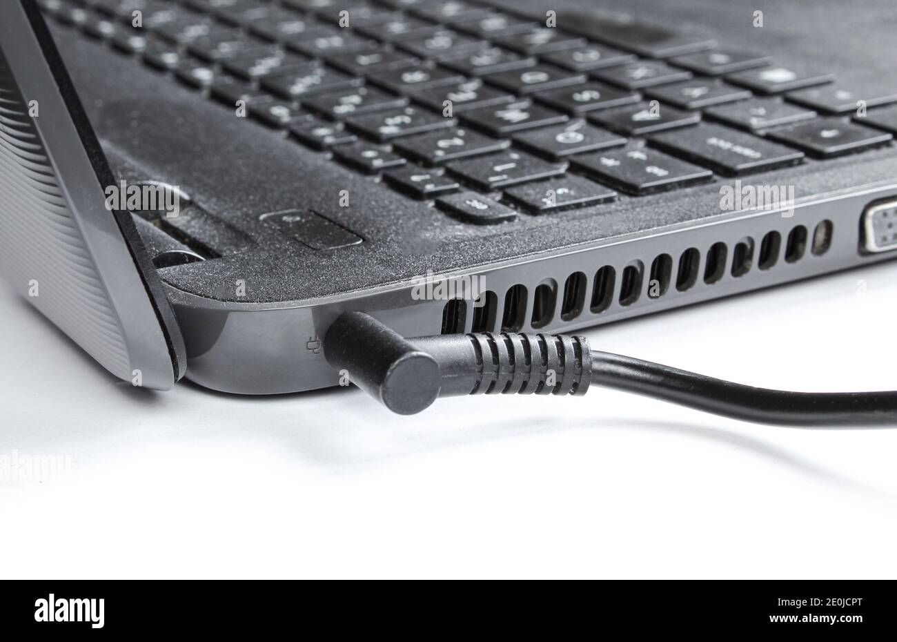 Electricity charging black laptop isolated on white background. Closeup ...