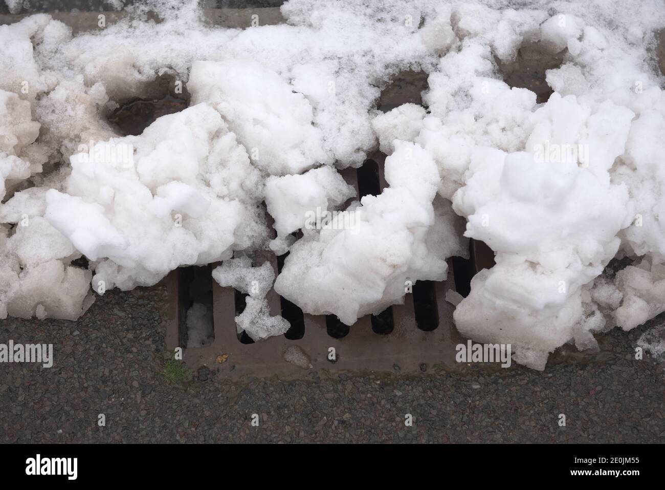 10 - Winter scene of a roadside drain covered in heavy chunks of white ...