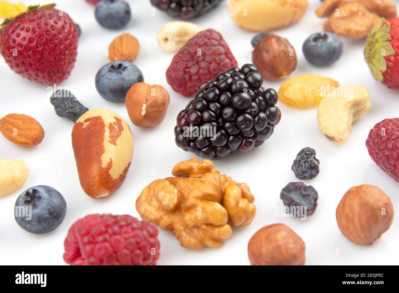 Different fresh berries and nuts on a white background. Vitamin and ...