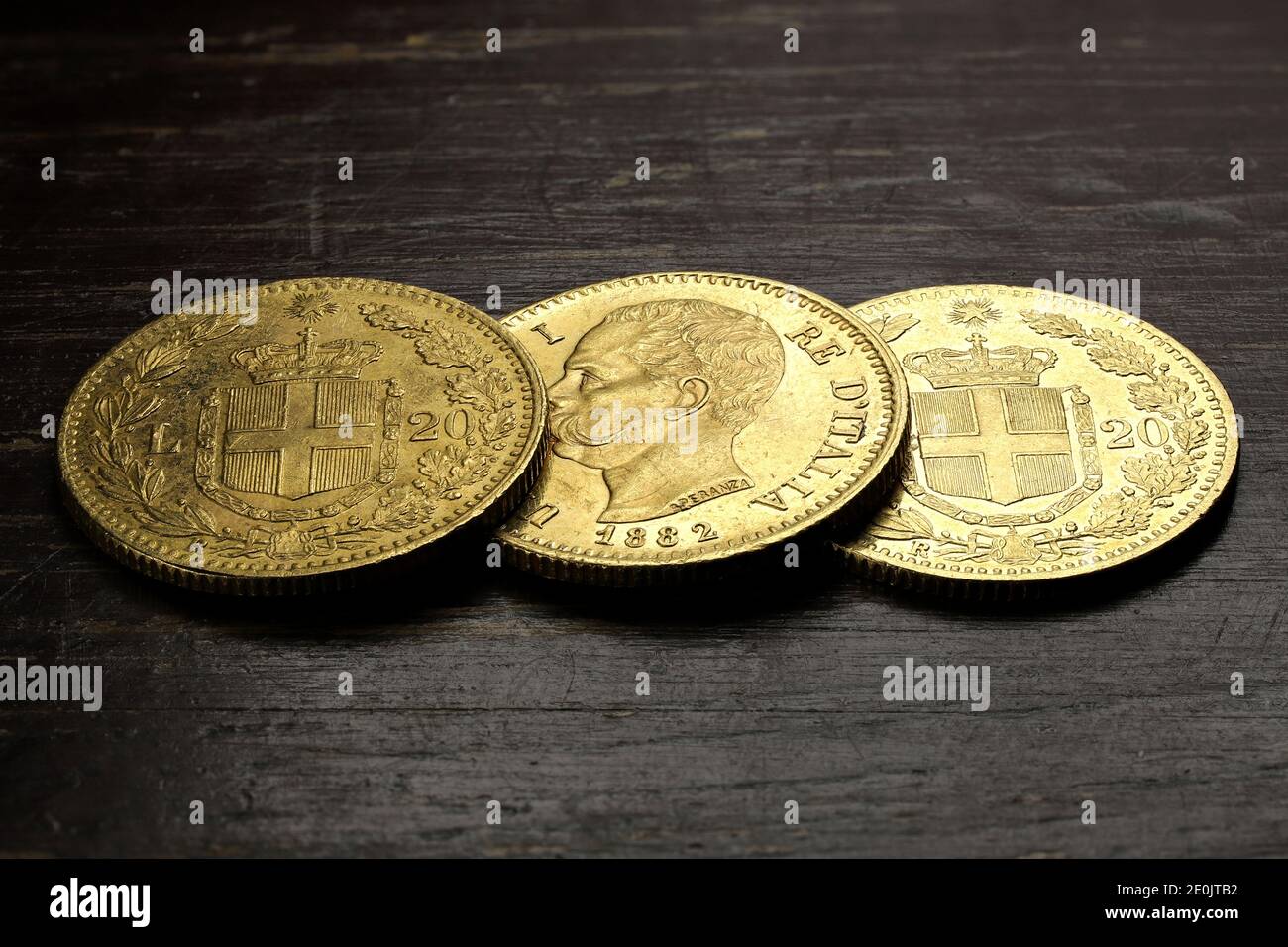 Italian 20 Lira gold coins on rustic wooden background Stock Photo - Alamy