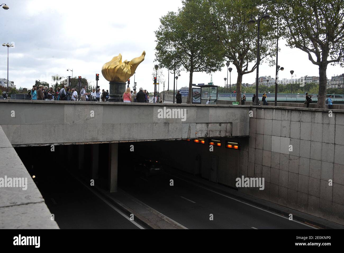 People stand in front of the "Flame of Freedom" statue at the Pont de l ...