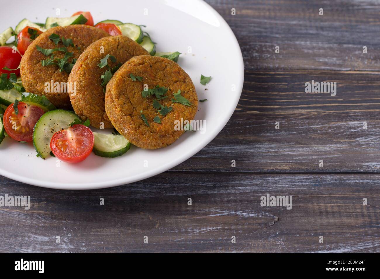 Carrot cutlets with amaranth, salad of fresh cucumbers and tomatoes on ...