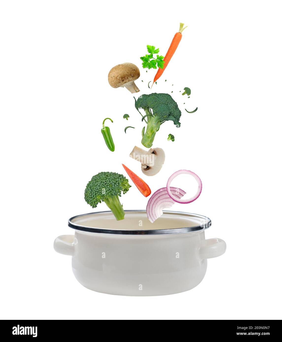 Fresh vegetables falling into a kitchen cooking casserole pot. Isolated ...