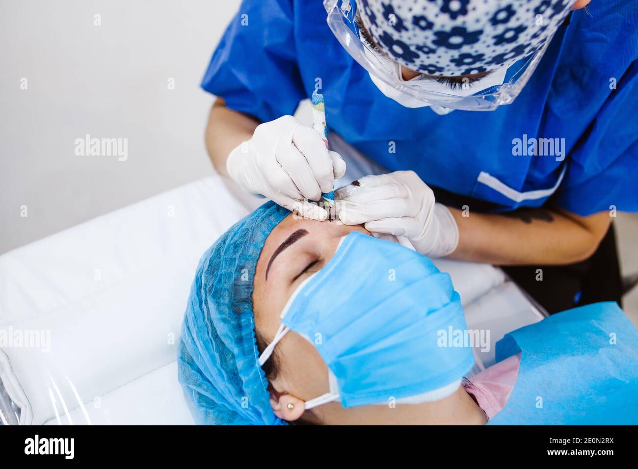 Latin woman Beautician Doing Eyebrow Tattooing For Female ...