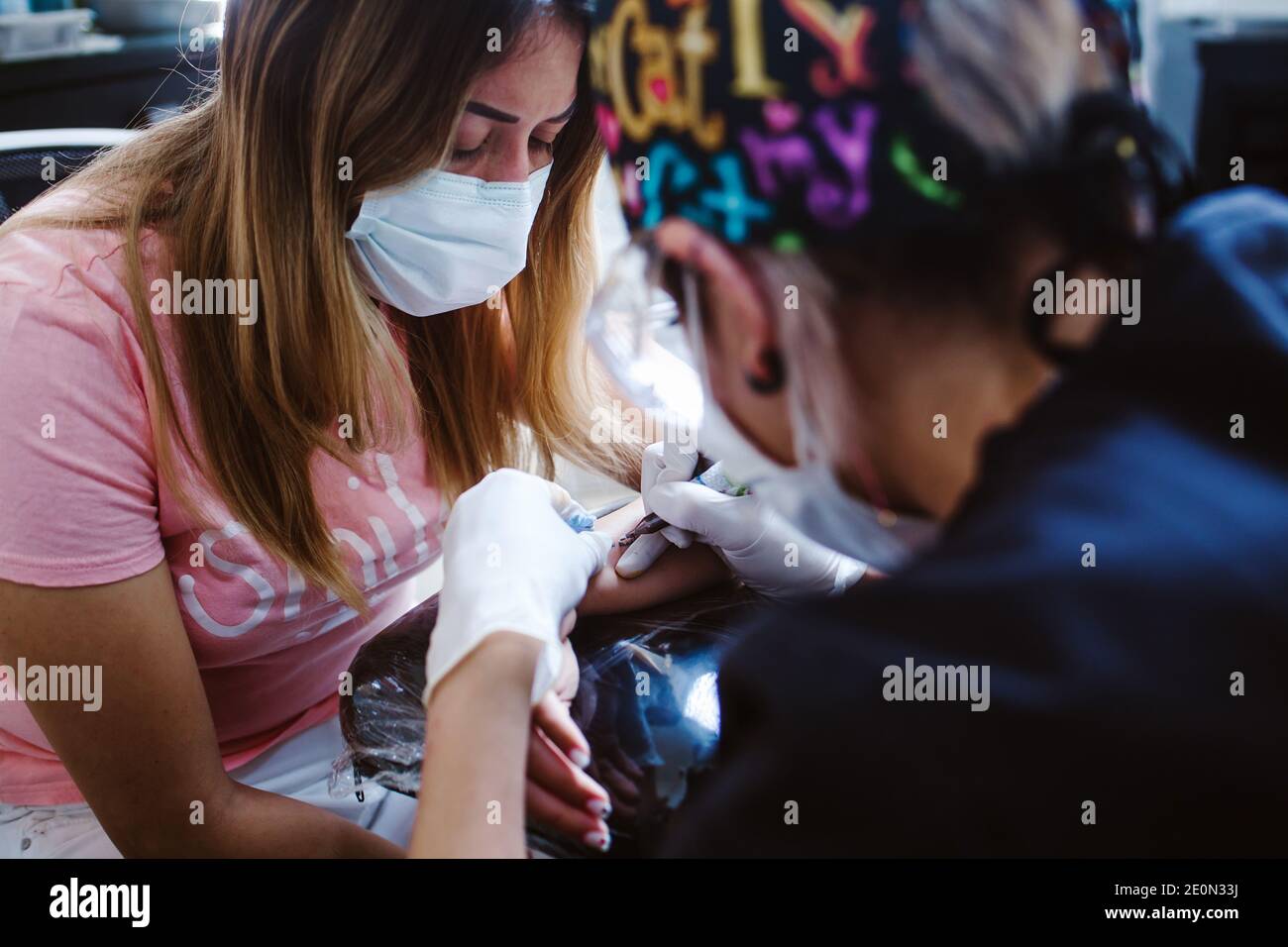 latin woman tattoo master showing a process of creation tattoo in ...
