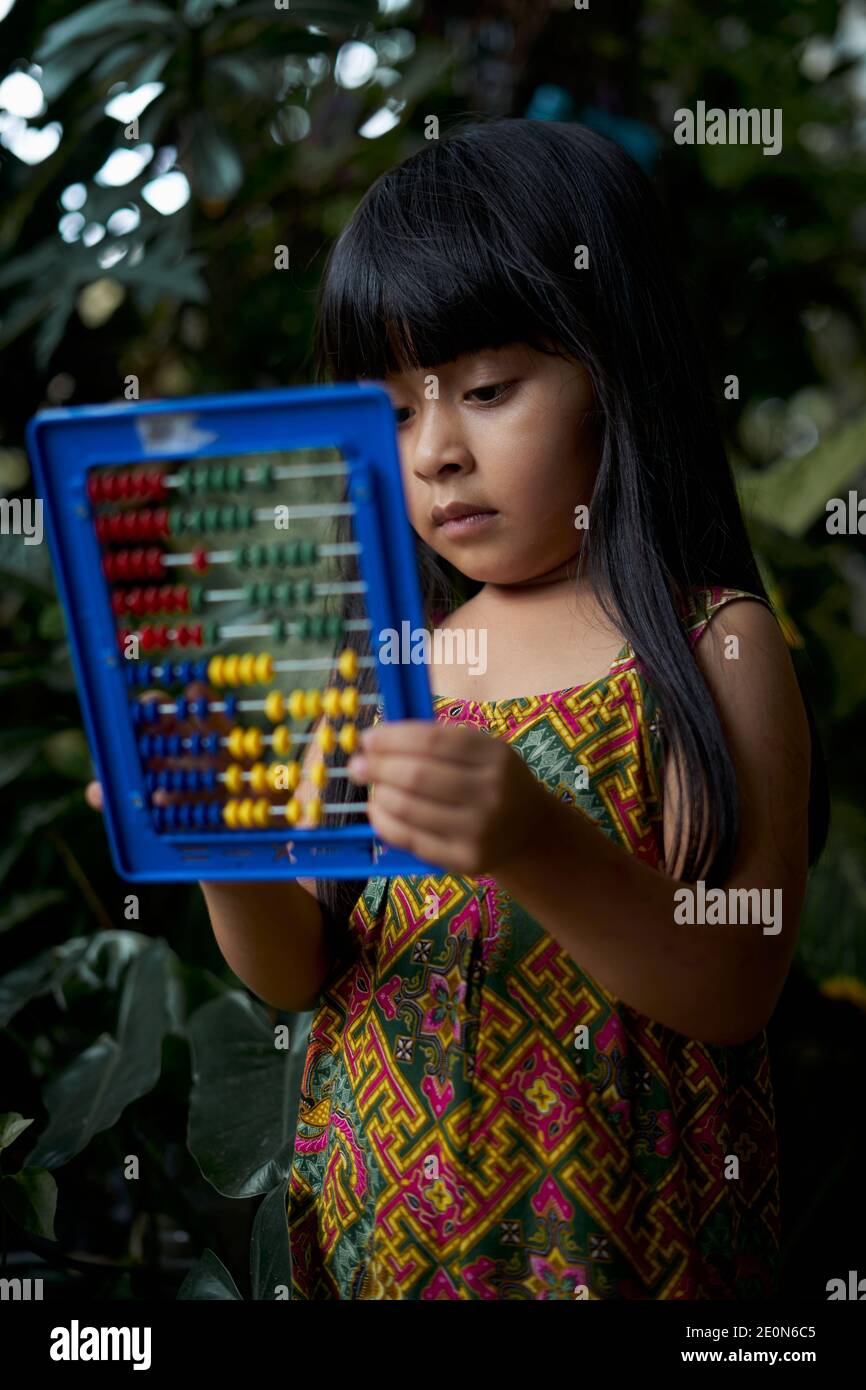 Cute little girl learn counting and Mathematics using abacus at park ...