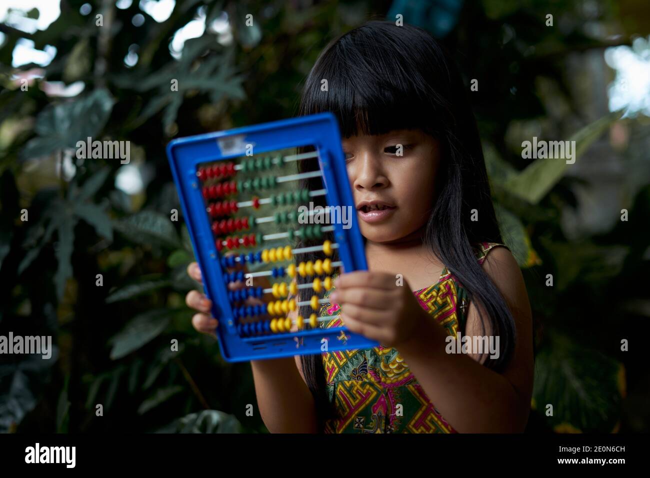 Cute little girl learn counting and Mathematics using abacus at park ...