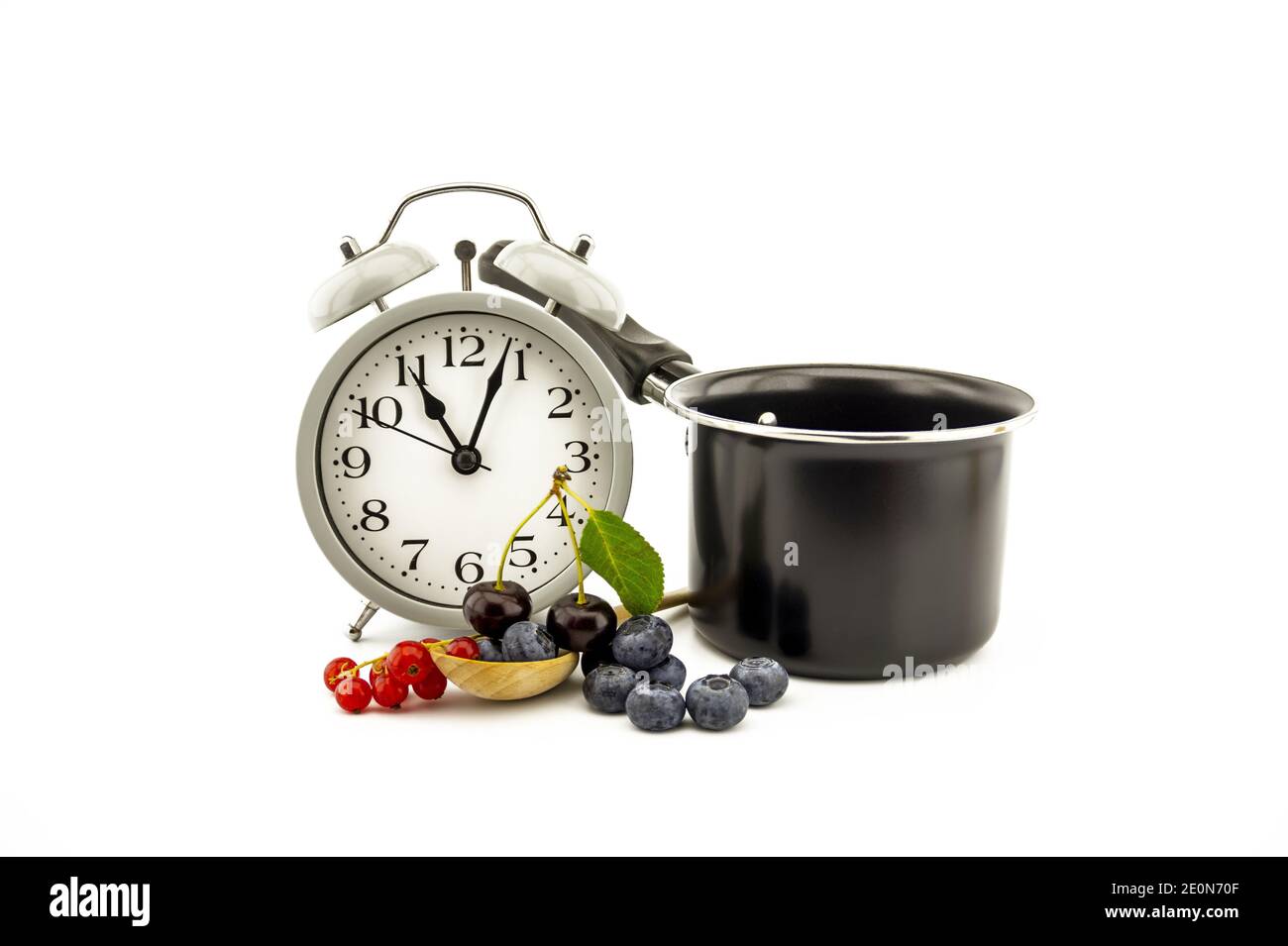 Culinary still life with old-fashioned alarm clock, pot, wooden spoons ...