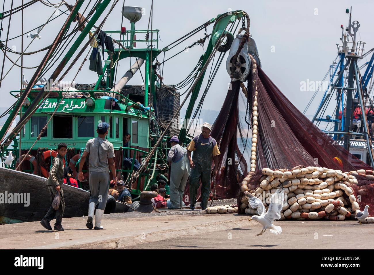 Fishermen return in a fishing trawler with their catch to the busy ...