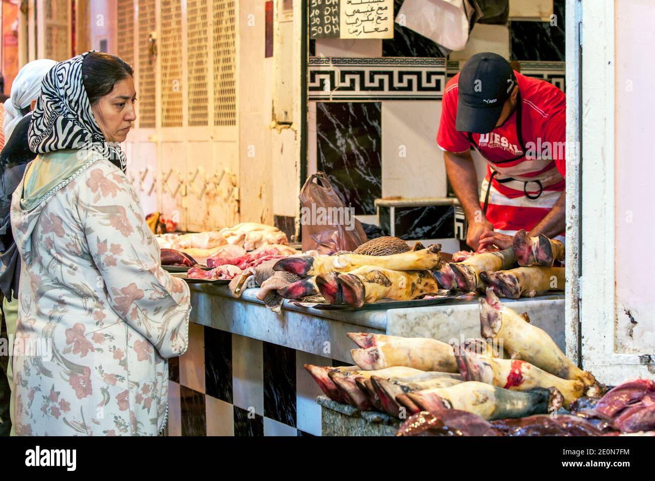 A lady looks at a selection of cow trotters for sale at a butcher shop ...