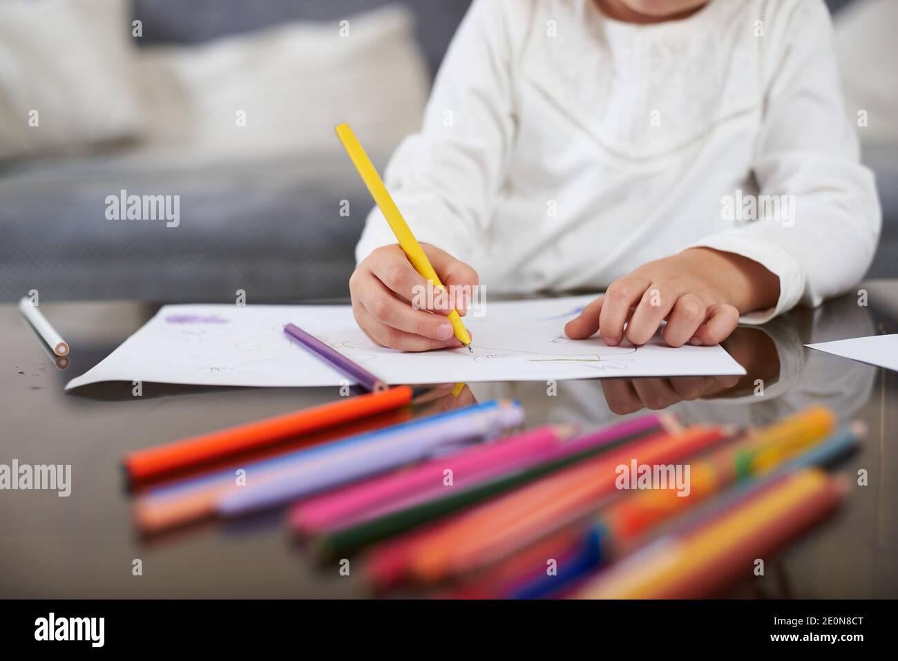 Closeup of a child hand holding a pen and writting something on a white ...