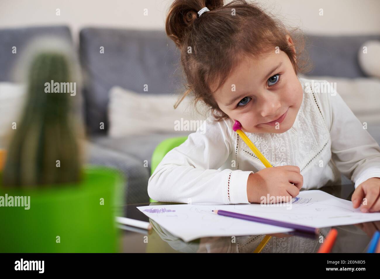 Beautiful little girl learning to write and looking at camera Stock ...