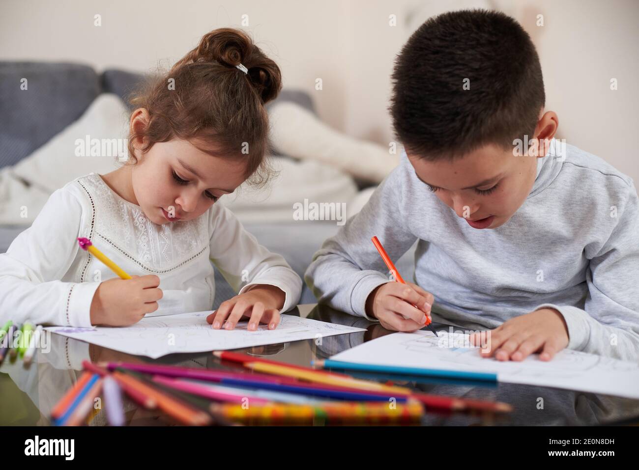 Two beautiful children drawing pictures with color pencils Stock Photo ...