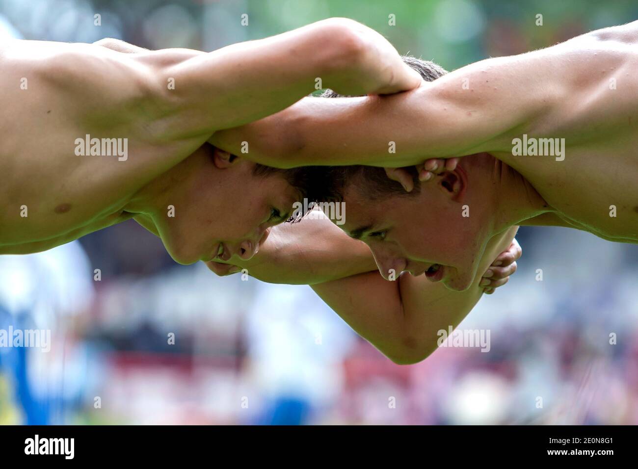 Young wrestlers lock arms during a close battle on the opening day of ...