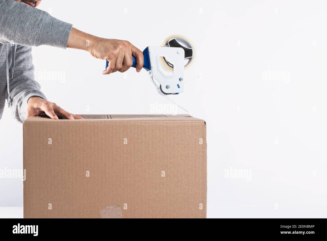 using a tape dispenser to close-up a box Stock Photo - Alamy