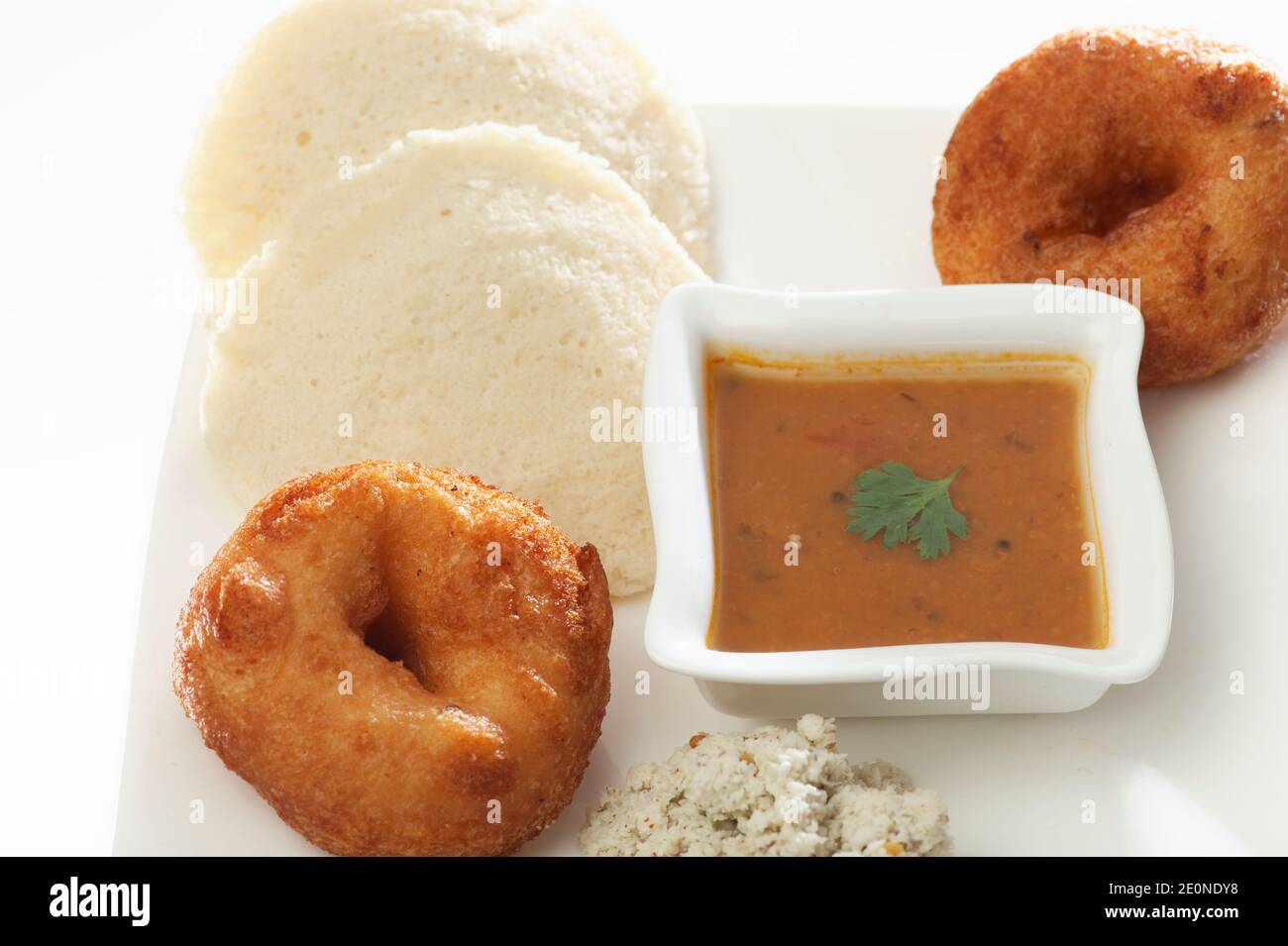 Indian fried snack medu vada & idli on a banana leaf with coconut ...