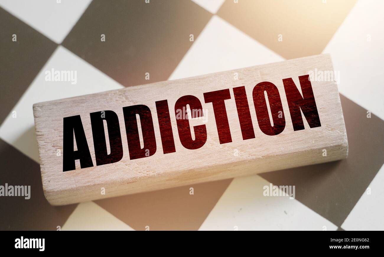 ADDICTION word written on wooden building block put on chess board ...