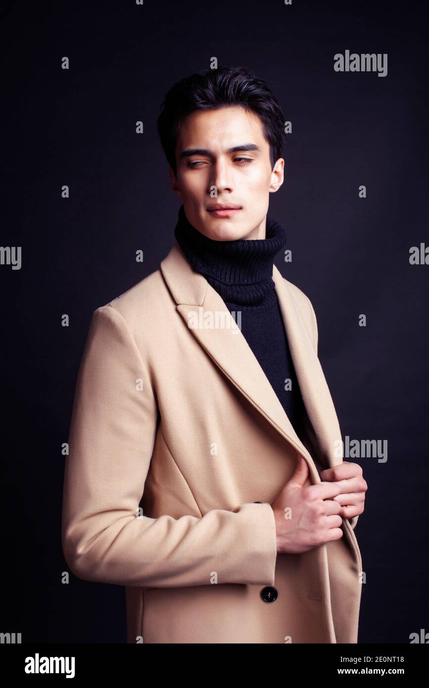 handsome asian fashion looking man posing in studio on black background ...