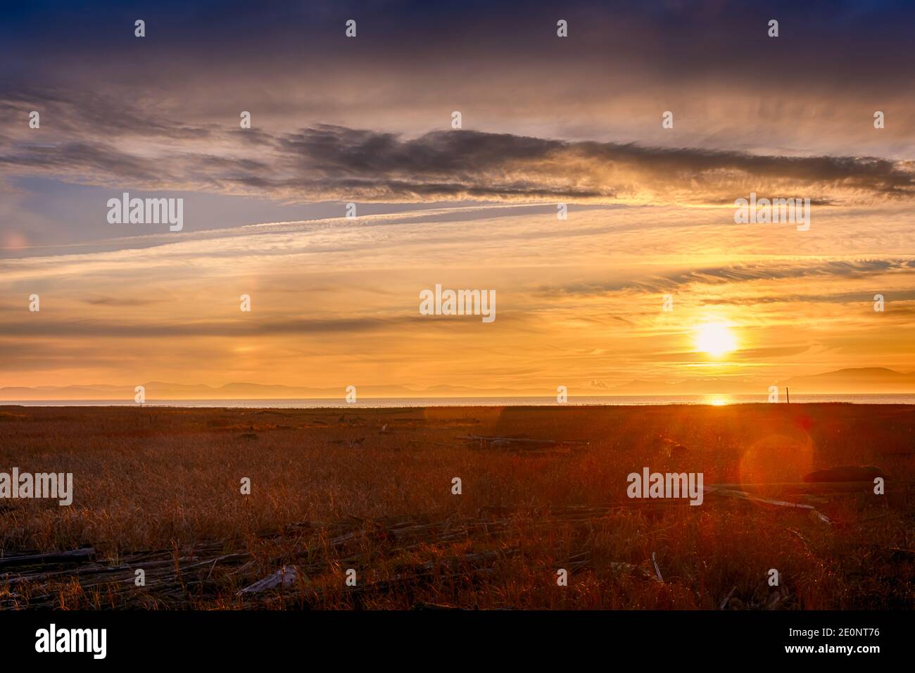 Beautiful HDR sunset landscape. The setting sun creates sun rays in the ...