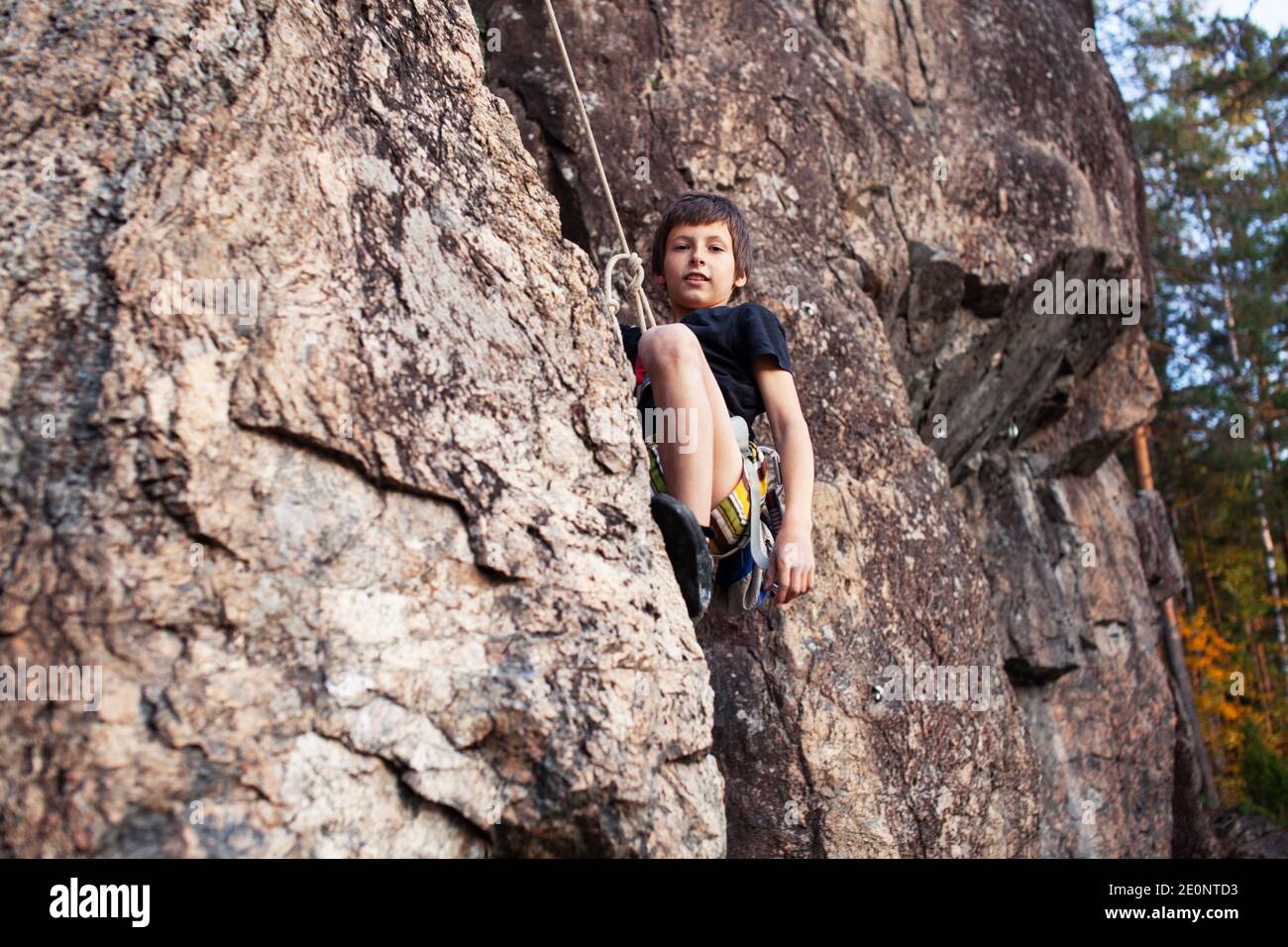 cute teen kid climbing on rock with insurance, lifestyle sport people ...