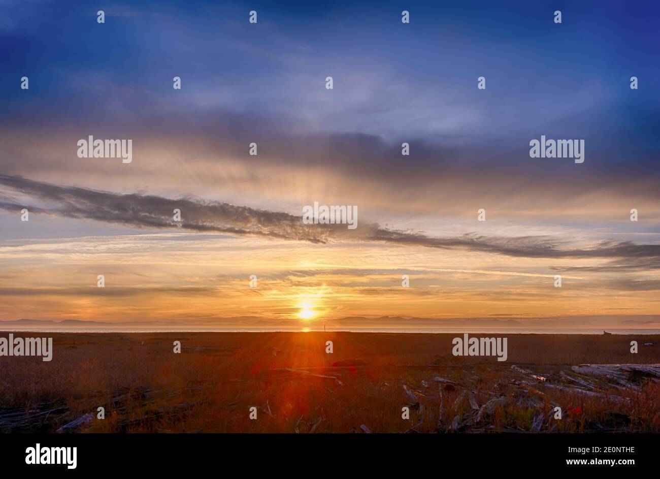 Beautiful HDR sunset landscape. The setting sun creates sun rays in the ...