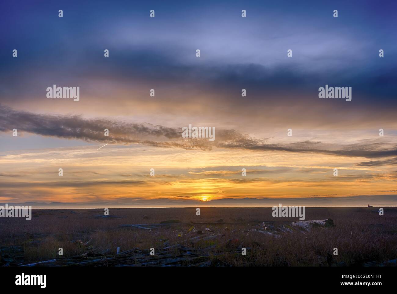 Beautiful HDR sunset landscape. The setting sun creates sun rays in the ...