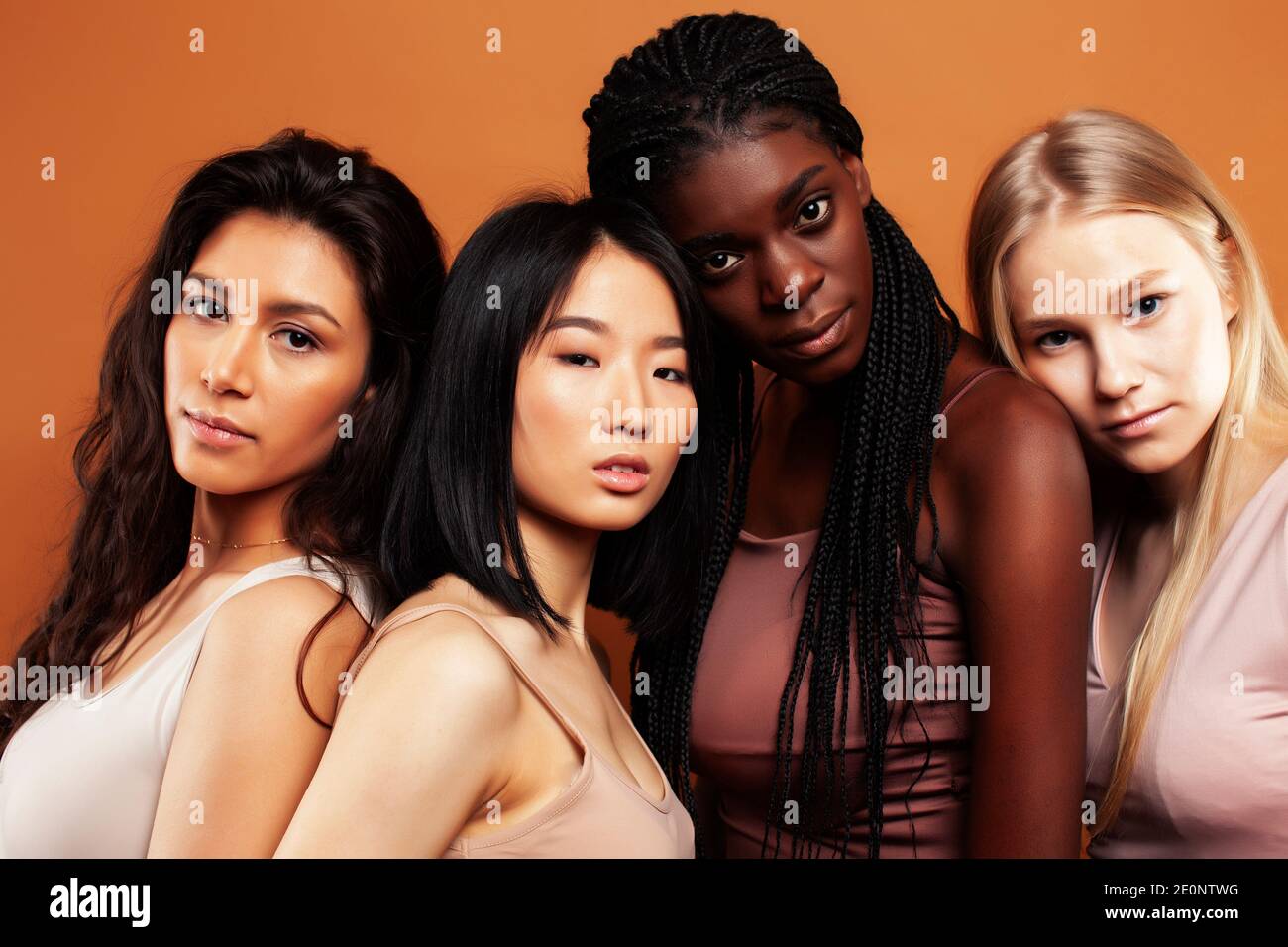 young pretty asian, caucasian, afro woman posing cheerful together on brown background ...
