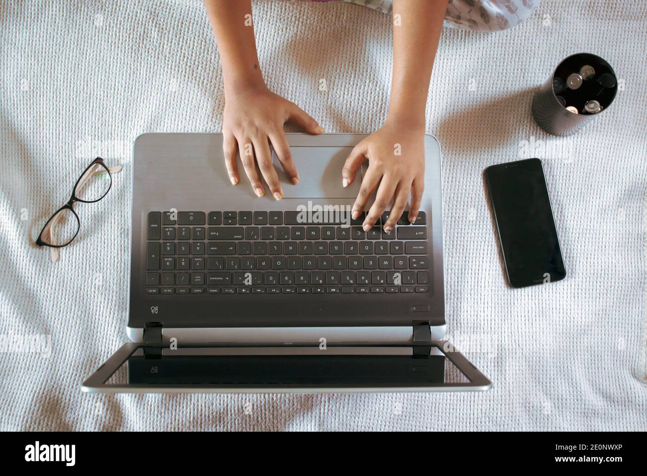 typing on a laptop while sat on bed Stock Photo - Alamy
